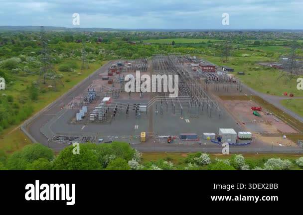 Aerial drone shot of electrical substation with powerlines pylons and ...