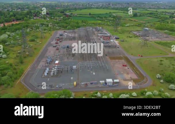 Aerial drone shot of electrical substation with powerlines pylons and ...
