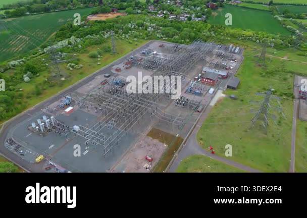 Aerial drone shot of electrical substation with powerlines pylons and ...