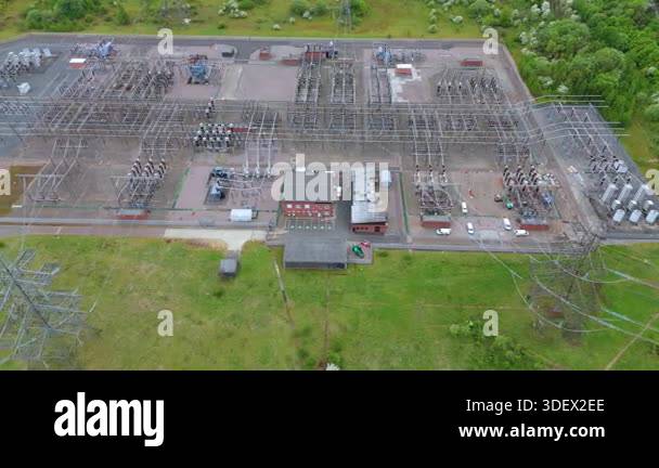 Aerial drone shot of electrical substation with powerlines pylons and ...