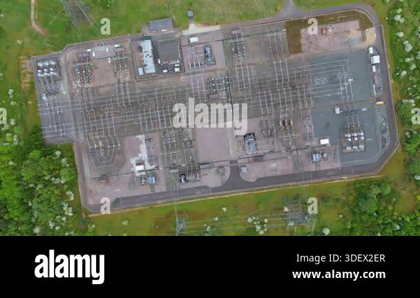 Aerial drone shot of electrical substation with powerlines pylons and ...