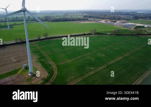 Aerial drone view of large wind turbine array and busy motorway highway ...