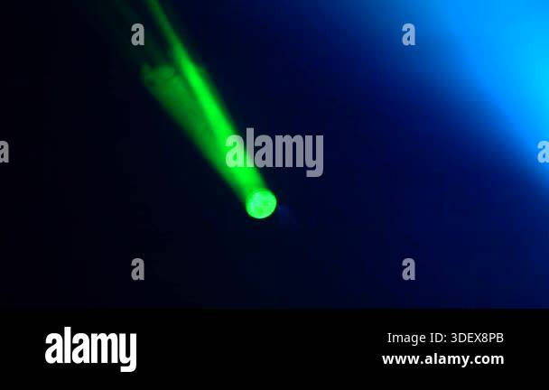 A green laser light emits from a source, progressively expanding and ...