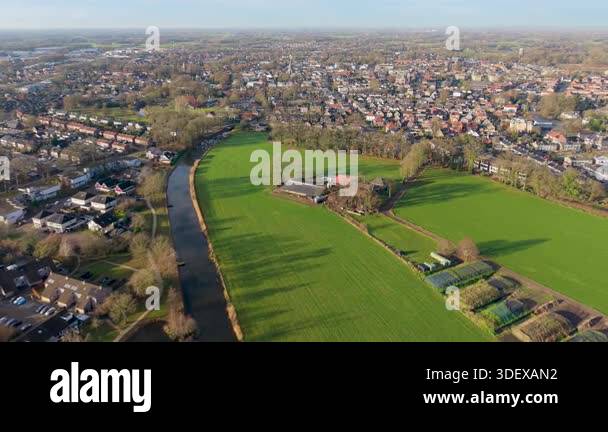 Aerial view of Dutch town dense homes, winding river, and green fields ...