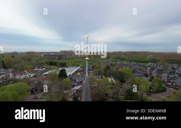 Aerial view of Dutch suburb gold tipped church steeple rises amid ...
