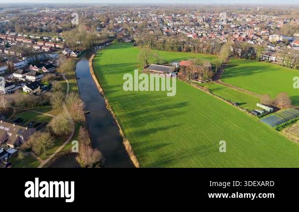 Aerial view of Dutch town dense homes, winding river, and green fields ...