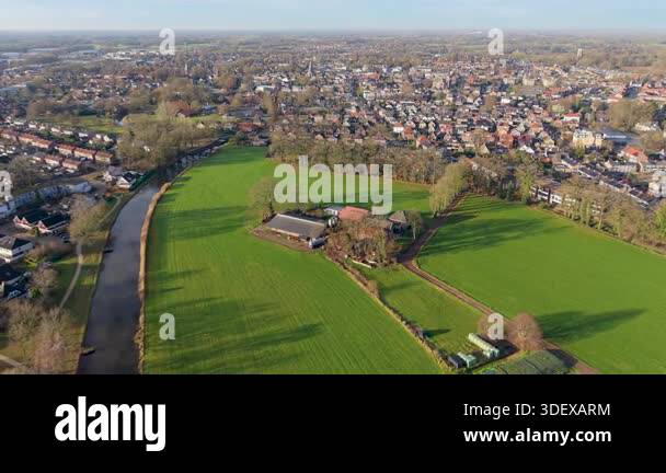Aerial view of Dutch town dense homes, winding river, and green fields ...