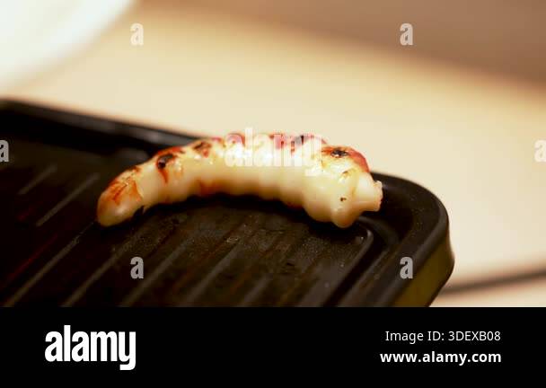 Video showing a shrimp grilling on a raclette grill with melting cheese ...