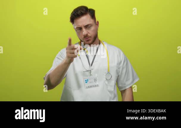 Caucasian young doctor with beard points finger, wearing stethoscope ...