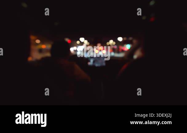 blurry backseat view during night rideshare trip, two passengers ...