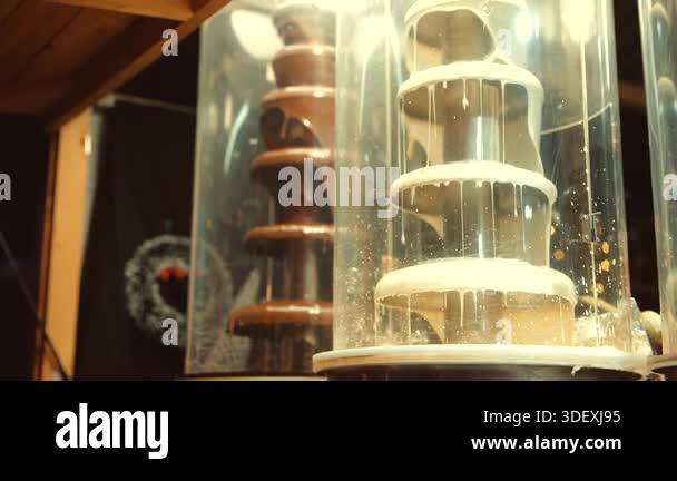 closeup chocolate fountain cascade at holiday market stall with glossy ...