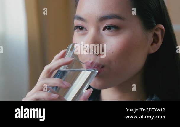 Close up Asian Korean woman drinking clean water at home morning ...