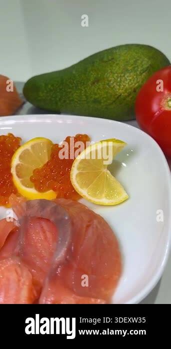 Sandwich with salmon, avocado, tomatoes and egg in a white plate on the ...