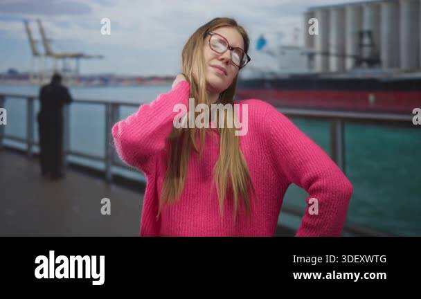 Woman touches neck with hand on street during boat cruise with ship ...