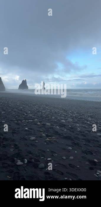 Vast Black Sand Beach with Reynisdrangar Basalt Stacks under Cloudy Sky ...