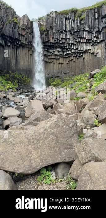 Tall Waterfall Cascading Down Hexagonal Basalt Columns in Iceland Stock ...
