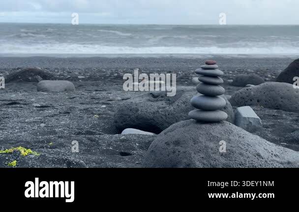 Delicate Stone Balance on Rugged Icelandic Black Beach with Distant Sea ...
