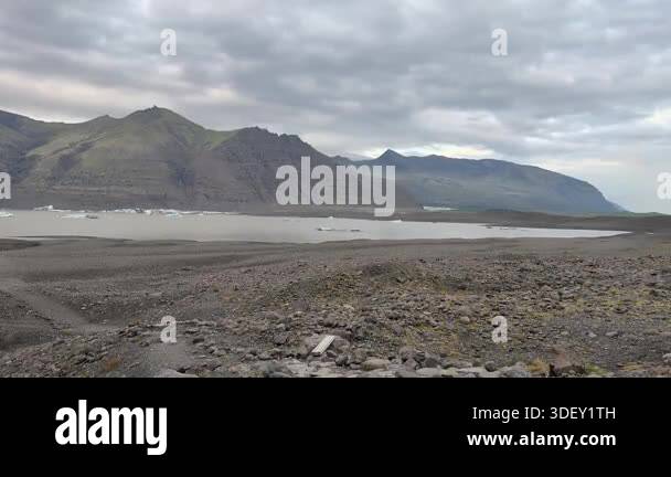 Expansive Gravel Plain with Distant Mountains under Cloudy Sky in ...