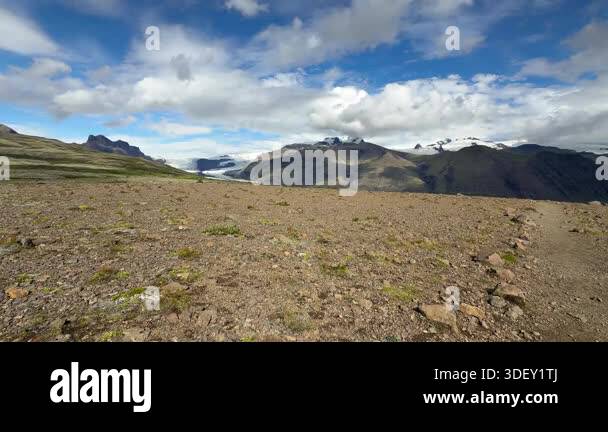 Barren Gravel Plain with Distant Mountains under Cloudy Sky in Iceland ...