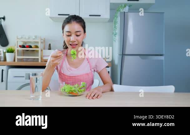 Woman eating fresh salad in modern kitchen setting Stock Video Footage ...