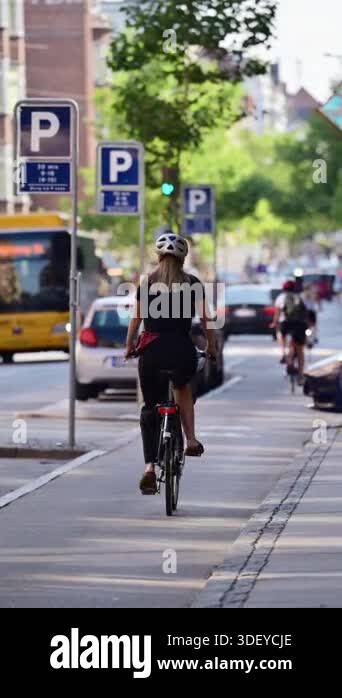 Copenhagen, Denmark - August 7, 2025: Cyclist riding a bike on a busy ...