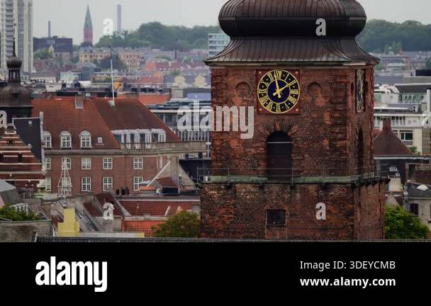 Old brick church clock tower rising above traditional red roof ...