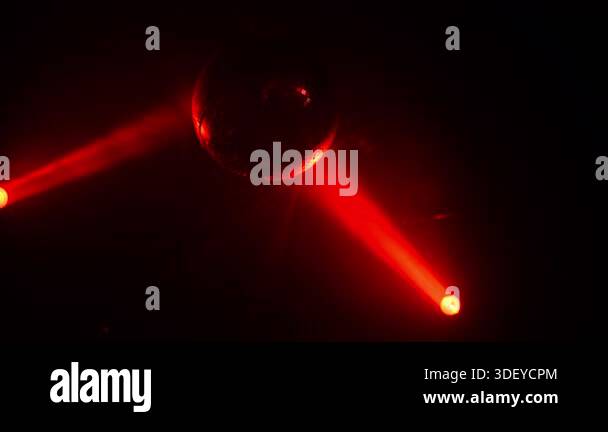 Disco ball reflecting bright red light beams, creating a vibrant dance ...