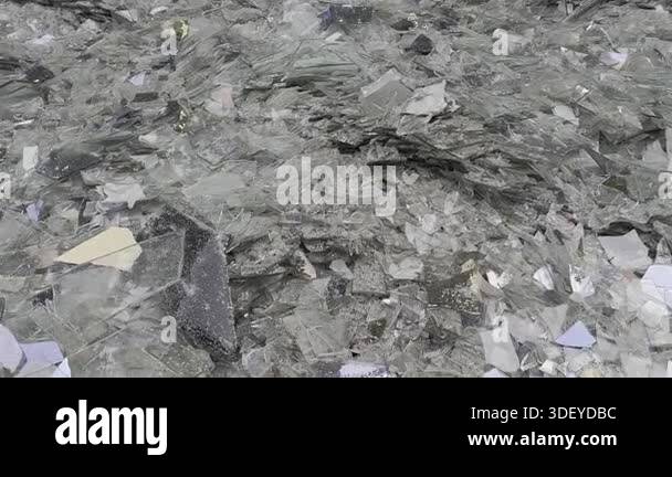 Large pile of broken glass shards scattered in outdoor debris area ...