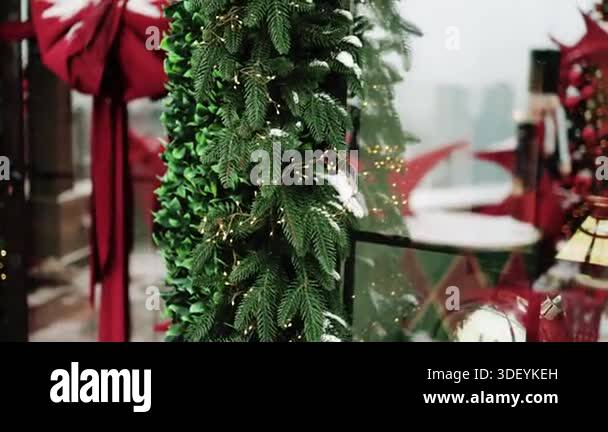 Lush Christmas tree illuminated with garland and decorated with red ...