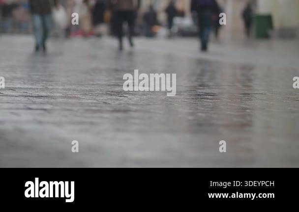 People walk on shiny streets after rain in a busy area Stock Video ...