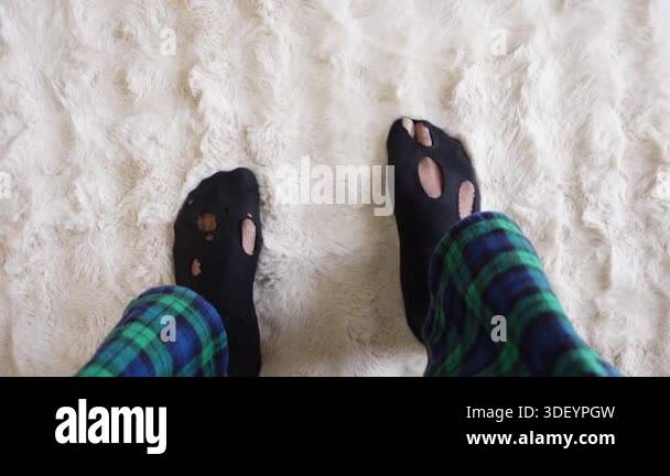 Person shows feet in worn socks on a soft rug in a home setting Stock ...