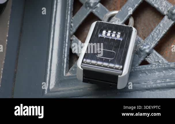 A lockbox is attached to a gate to secure important items safely Stock ...