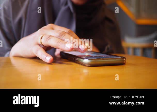 Person touches a smartphone screen while sitting at a table Stock Video ...