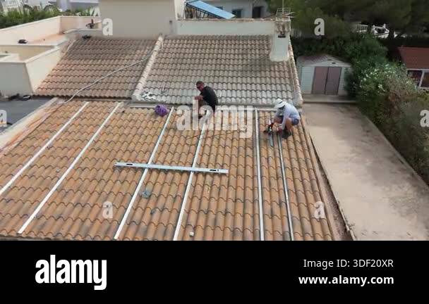 Workers Installing Mounting Rails for Solar Panels on Tiled Roof Stock ...
