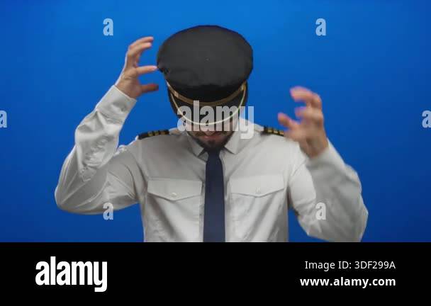 Young hispanic pilot adjusting cap with stress on blue background ...