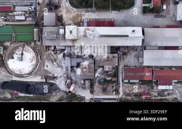 Aerial view of the sugar factory; smoke rising from the chimneys and ...