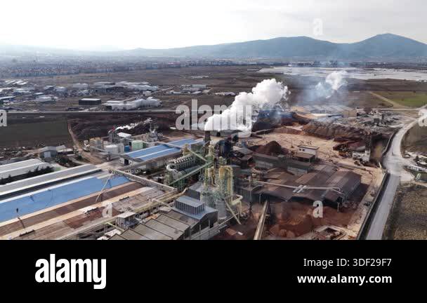 Industrial production process at a chipboard factory. Thick white smoke ...