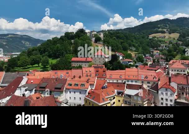 Aerial summer footage of Wolfsberg showing town center, church towers ...
