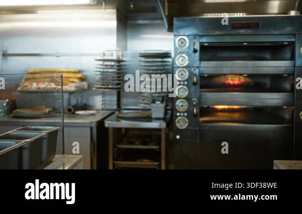 Industrial kitchen with defocused bakery oven and metal racks, soft ...