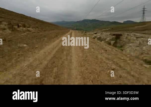 A cloudy day, high-speed driving on a dirt road. View from the cars ...