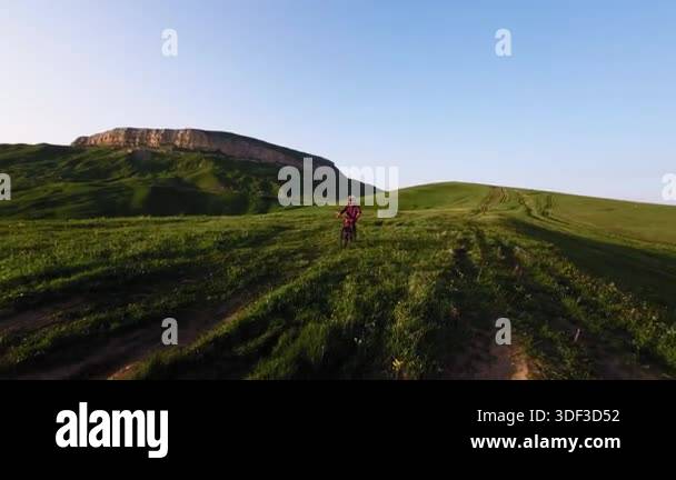 Young athlete cyclist in helmet and mask doing wheelie trick riding on ...