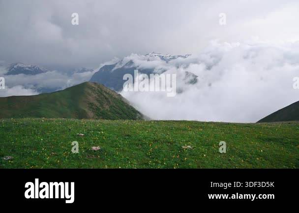 Evening landscape low clouds crawling over mountains at dusk. Fast ...