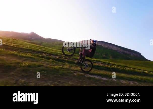Aerial tracking fpv drone footage of a cyclist doing a wheelie stunt on ...
