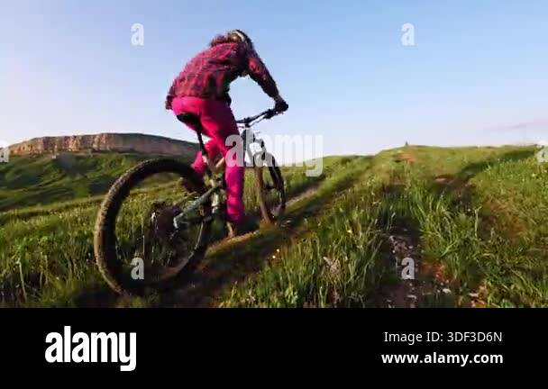 Young athlete cyclist in helmet and mask doing wheelie trick riding on ...