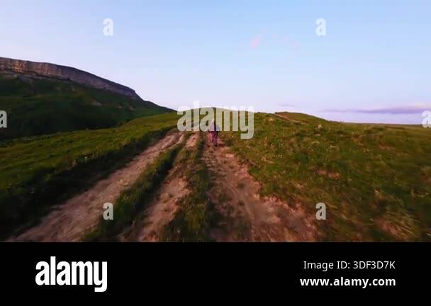 Aerial view fpv quadcopter drone footage following a cyclist riding a ...