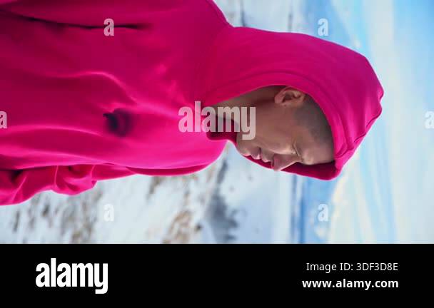 Portrait of attractive Caucasian young man with shaved hair in pink ...