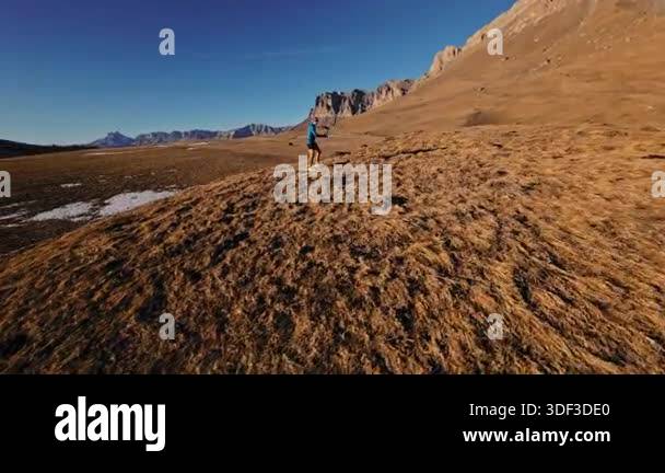 Aerial view of a man in sportswear running fast across fields. A guy ...