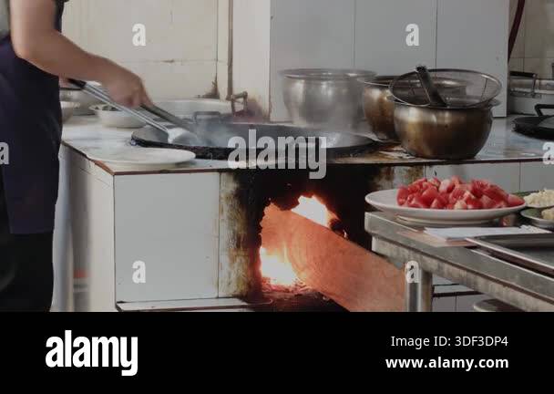 A chef is cooking using a traditional rural wood-fired stove Stock ...