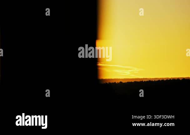 Golden sun emerges from behind a foreground silhouette, illuminating ...