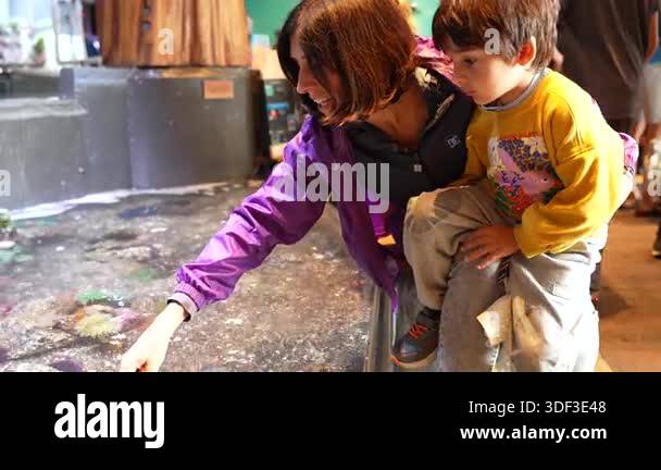 Mother gently holding son while exploring marine life in interactive ...